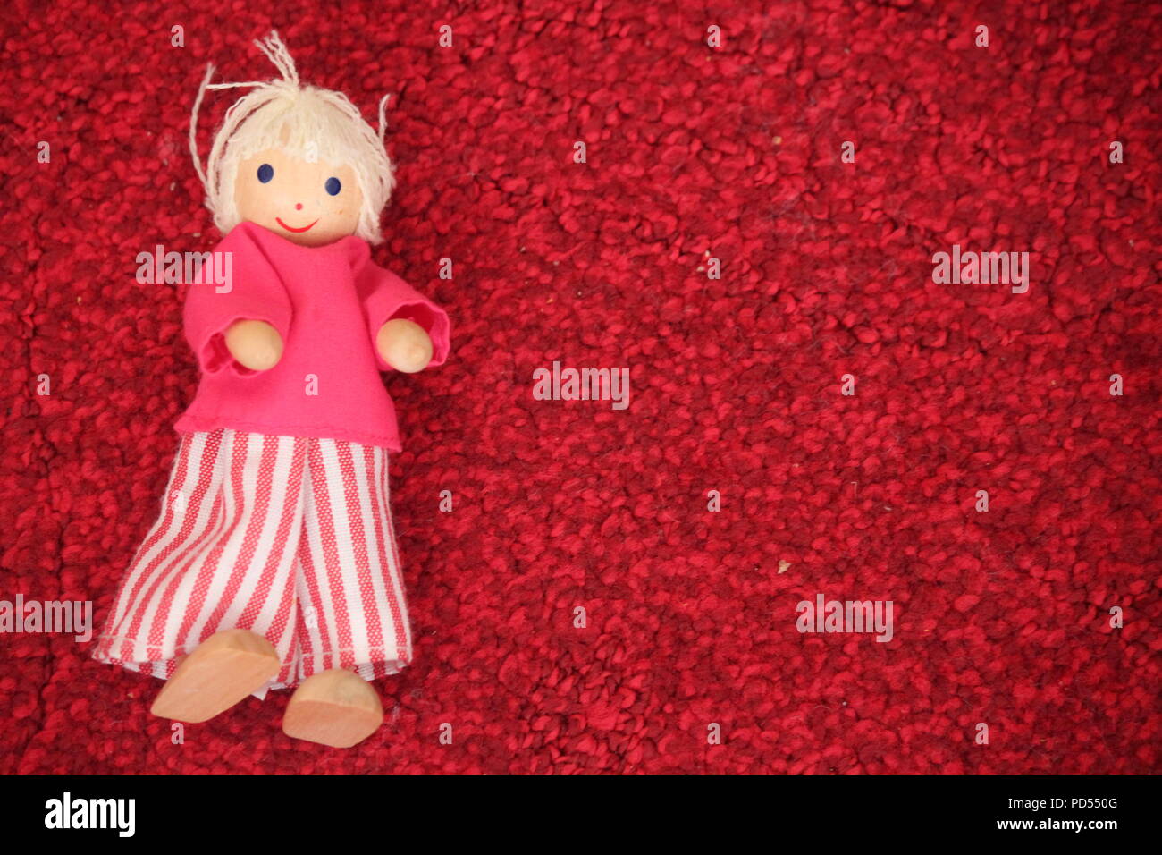 Toy doll on a red carpet Stock Photo - Alamy
