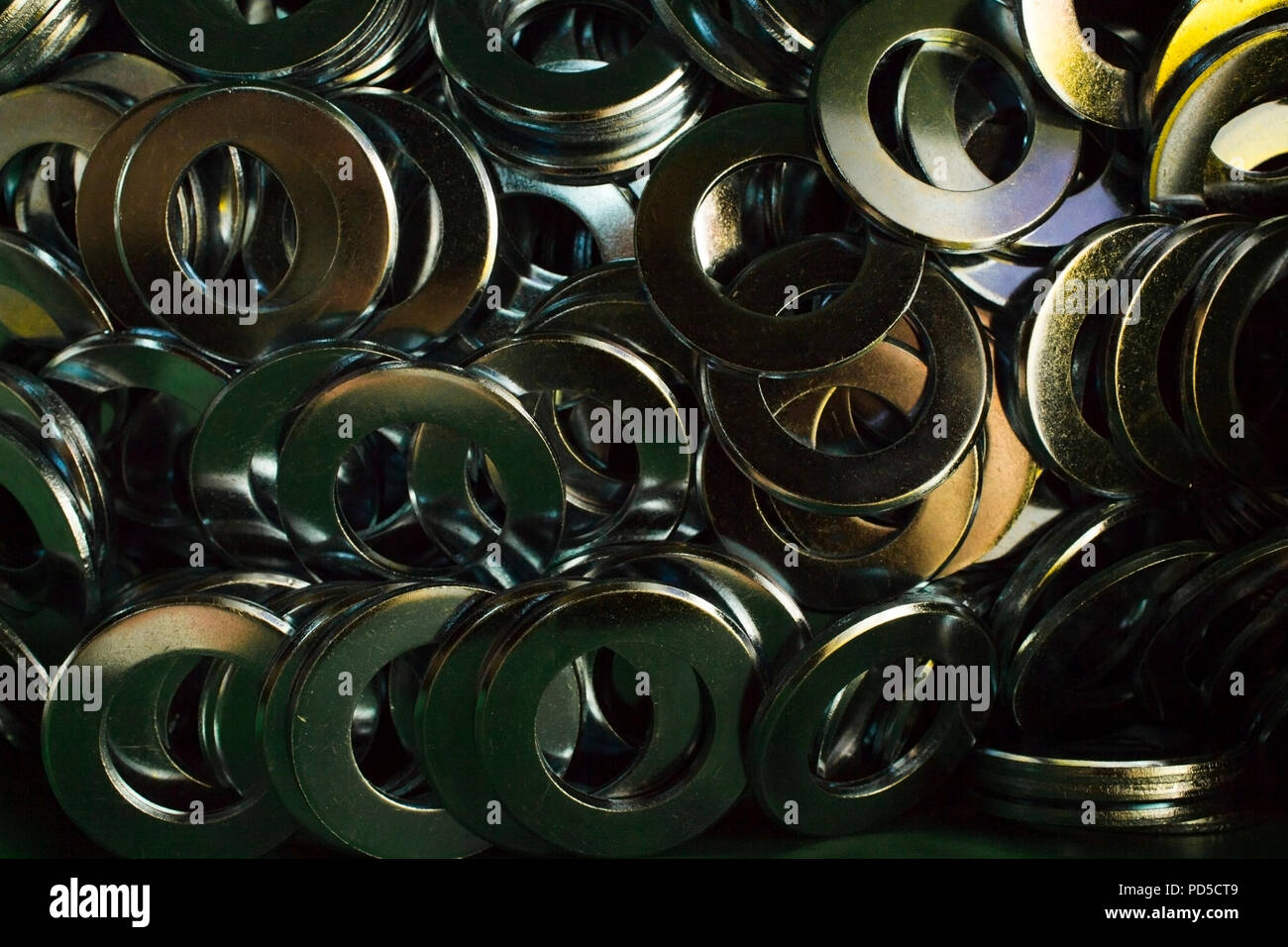 Pile of galvanized steel washers reflecting different colors in the sun ...