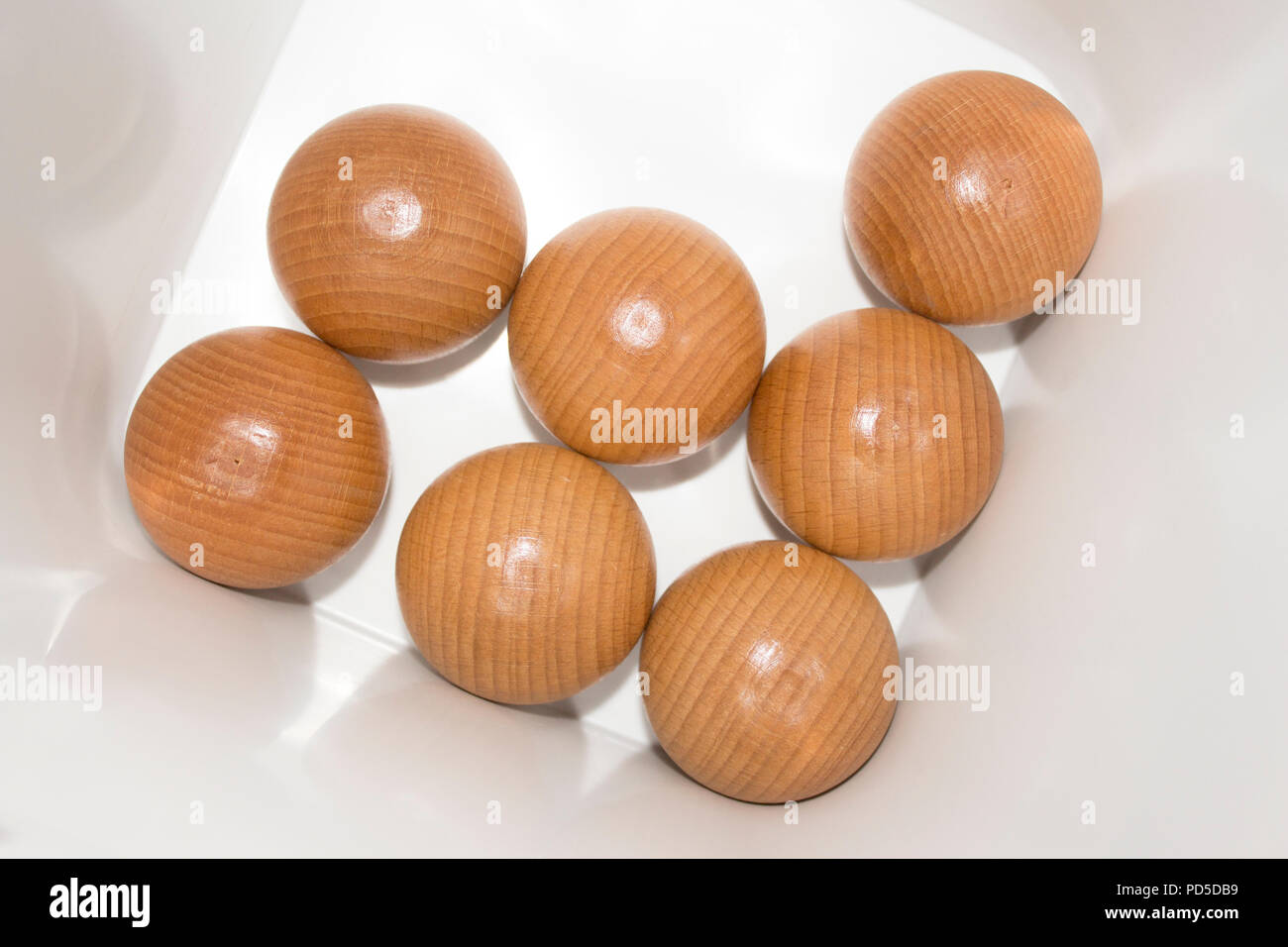 Seven round wooden balls in a white square box Stock Photo - Alamy
