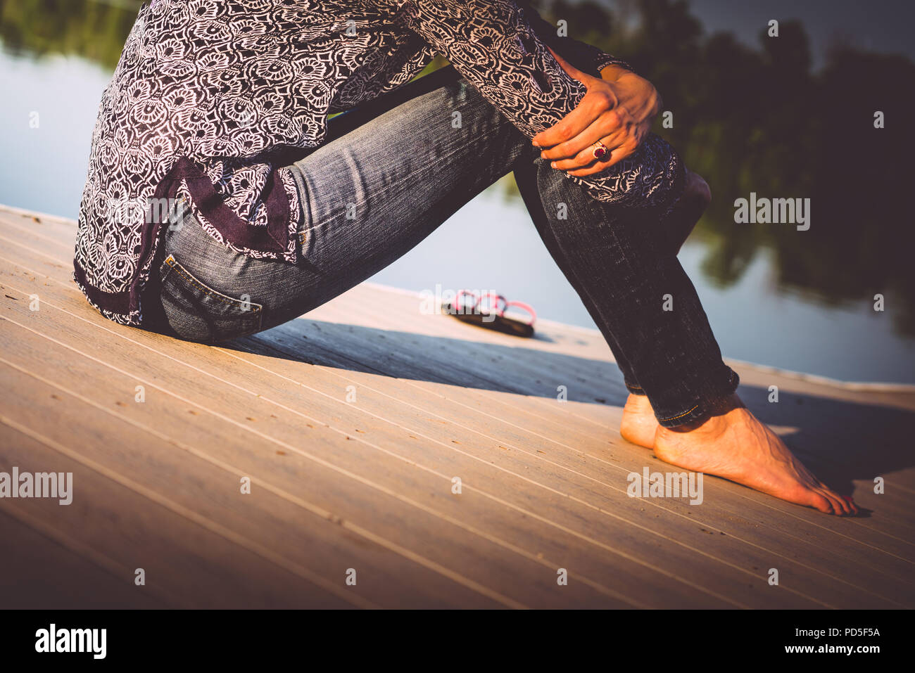 retro film dutch angled lady sitting on dock by the lake. retro film ...