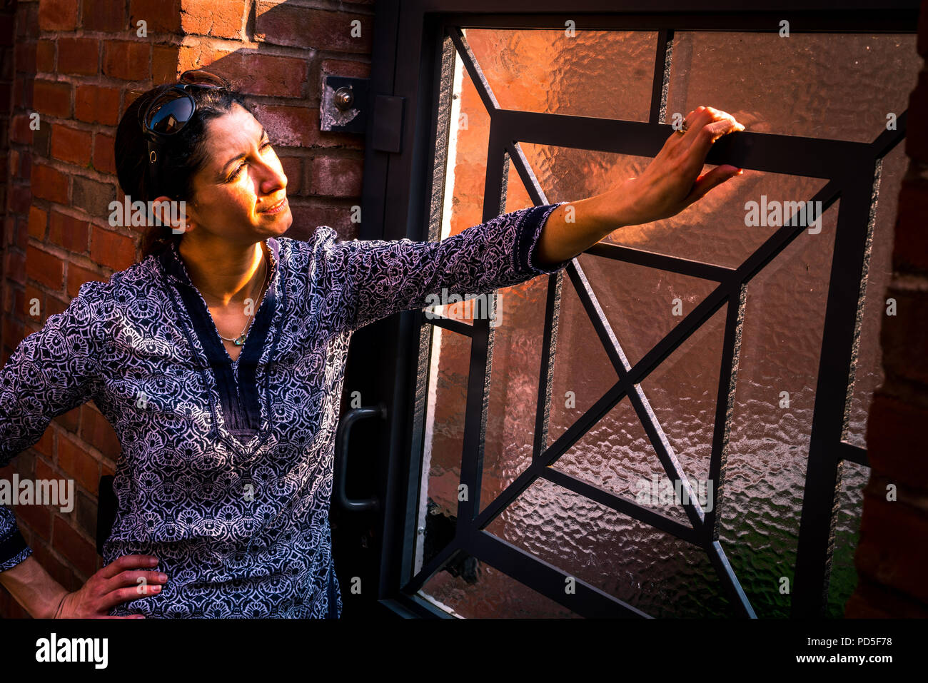Woman looking up at the glass door before going in Stock Photo - Alamy