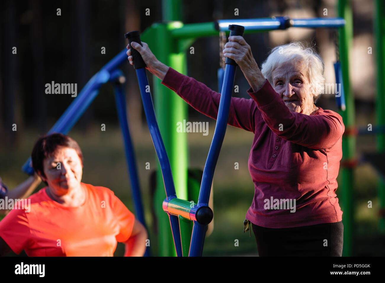 Elderly woman is doing exercises on the sport playground in the Park Stock Photo - Alamy