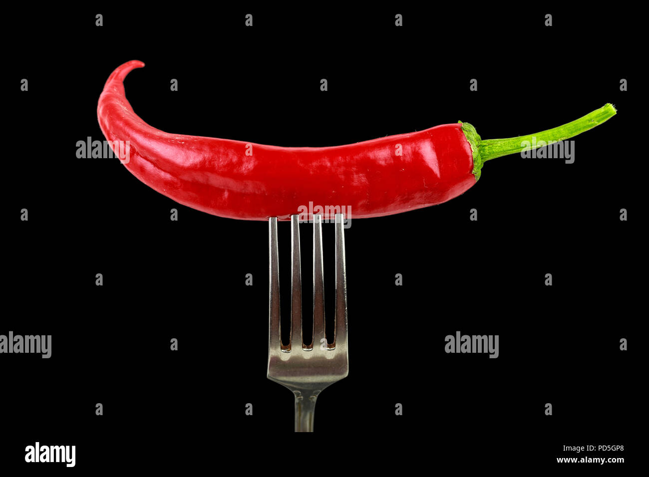 red hot chili pepper on the fork on black background. Spicy food ...