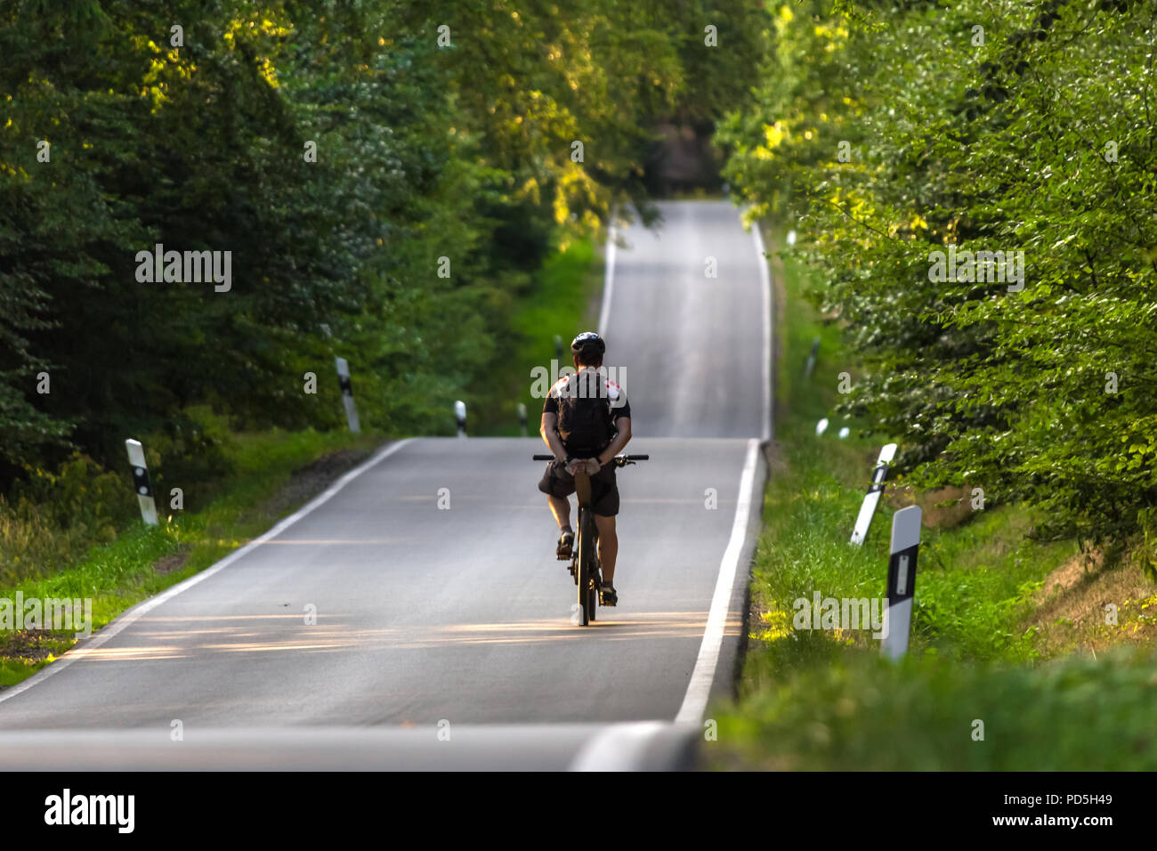 a bike rider on an country road Stock Photo - Alamy