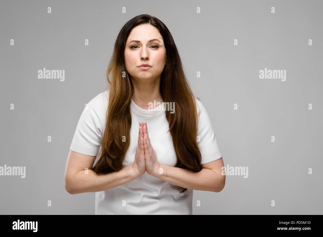 Portrait of emotional sad upset plus size model standing in studio ...