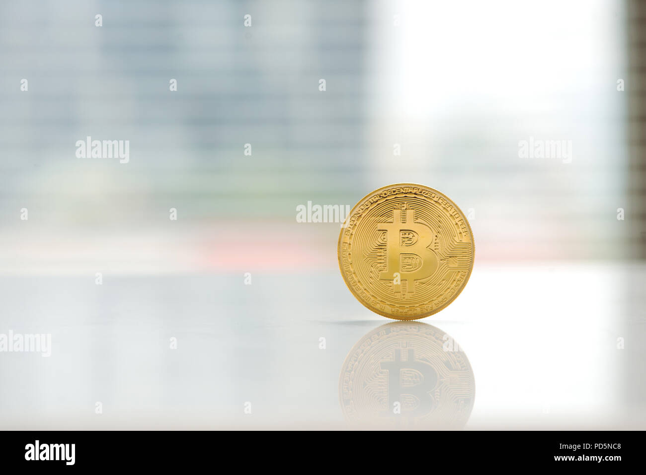 Digital currency physical gold bitcoin coin on the table near window ...