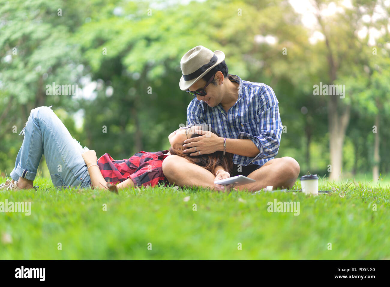 full length of happy female lying on happy man lap in park Stock Photo ...