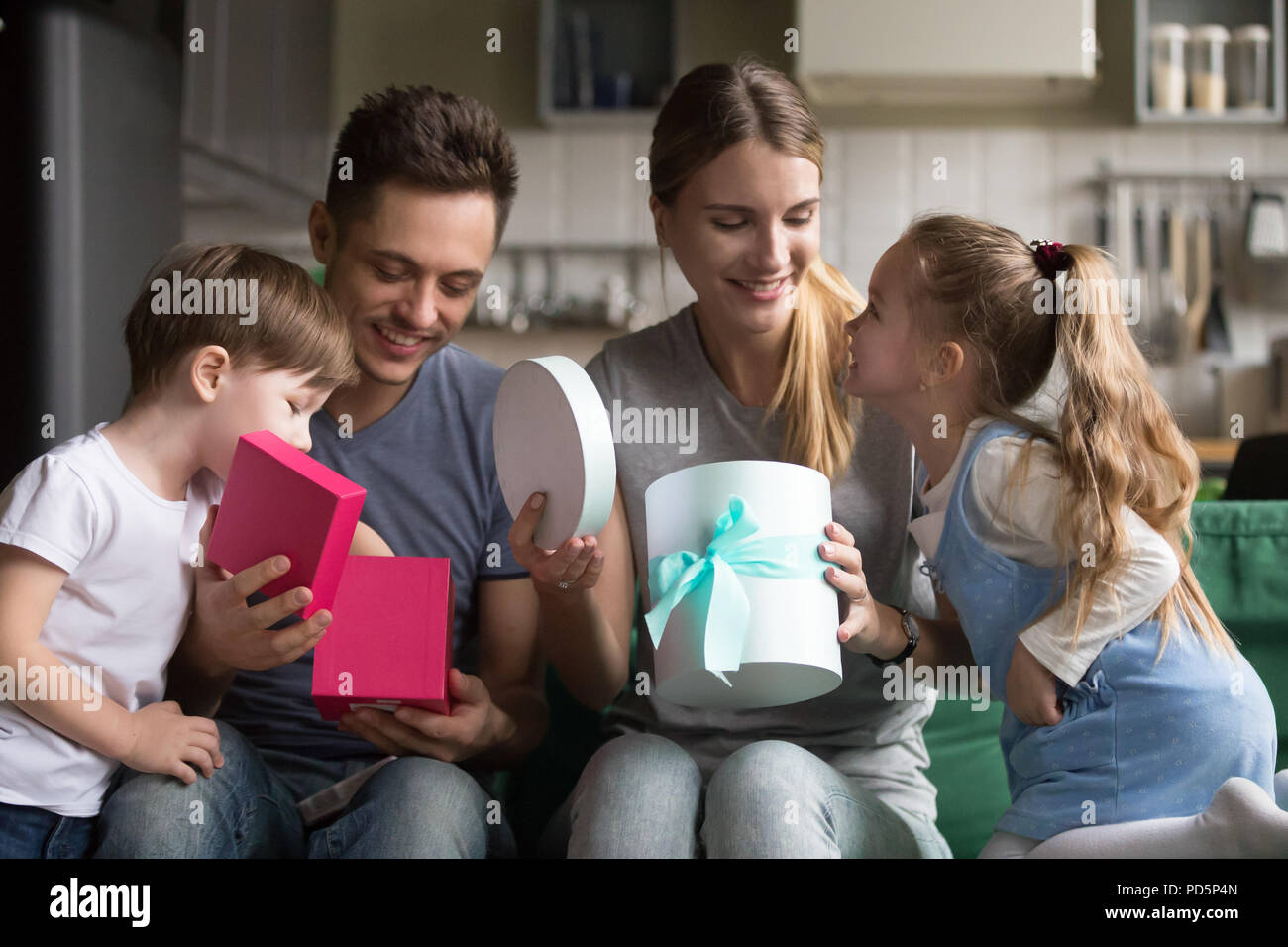 Happy excited parents opening gift boxes with presents from kids Stock ...