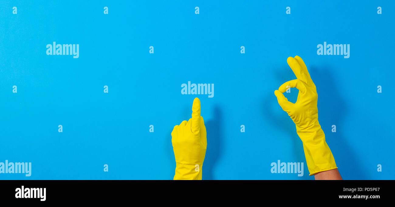 Woman hands with yellow rubber gloves making a gesture meaning ok and ...