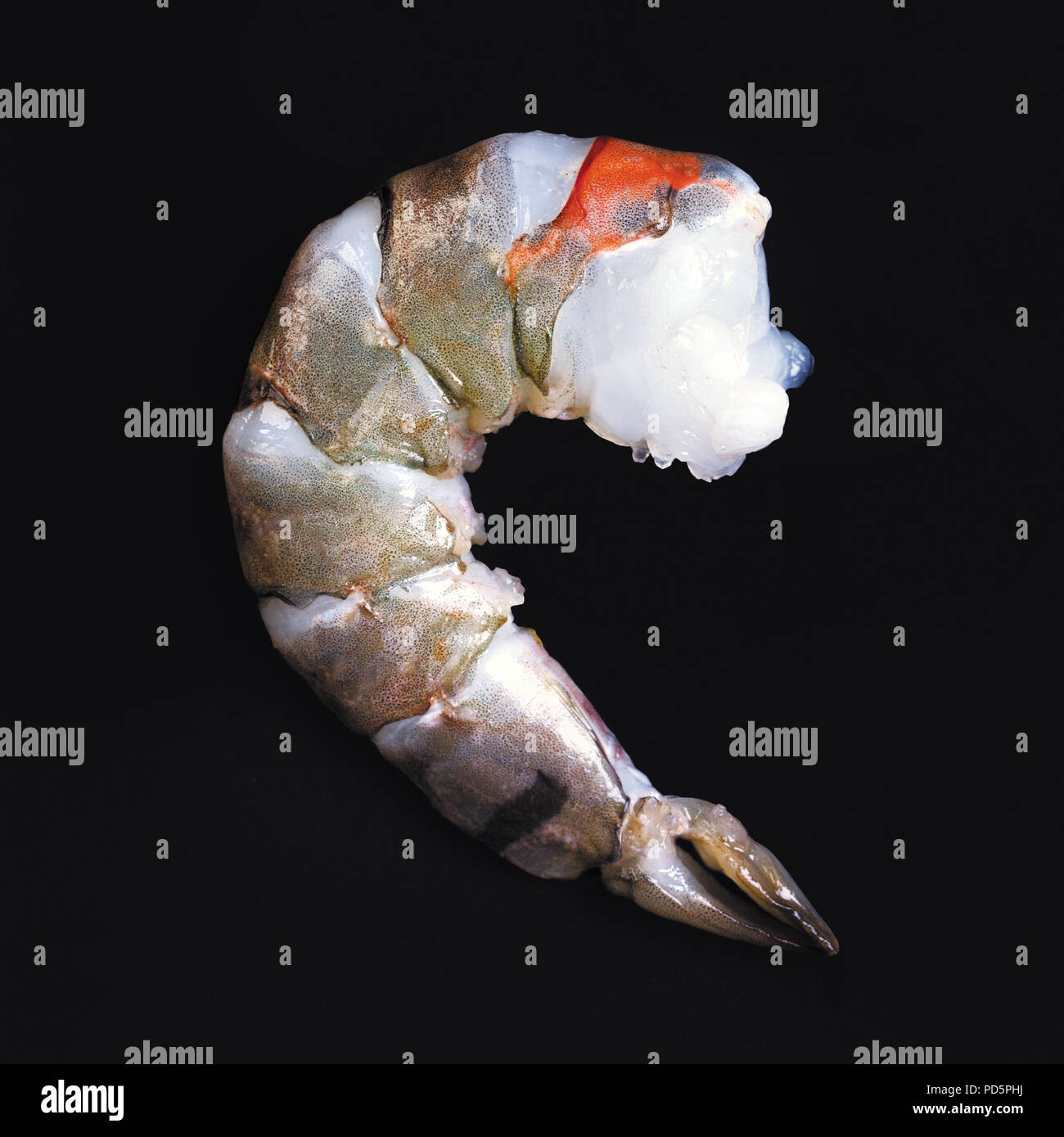 One peeled prawn on a black background Stock Photo - Alamy