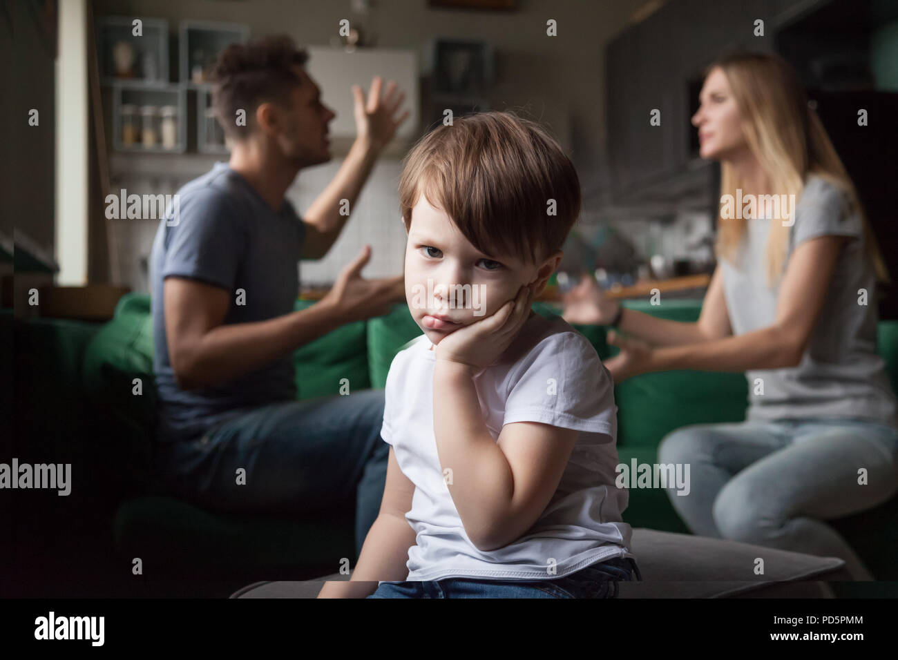 Sad kid son feeling bored and tired of parents fighting Stock Photo - Alamy