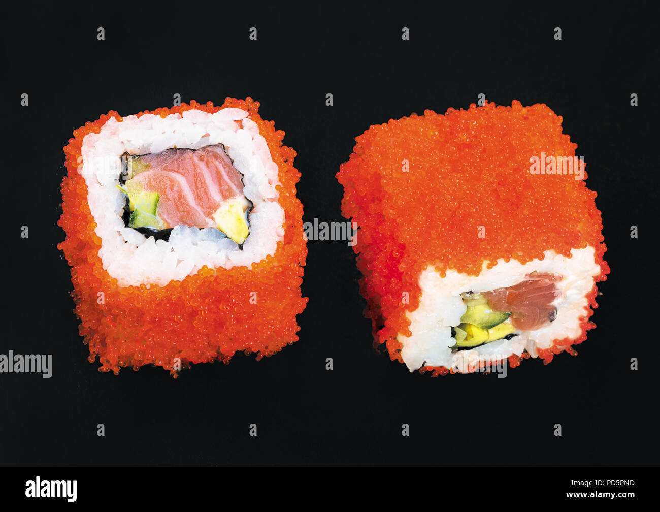Salmon tobiko rolls on a black background Stock Photo - Alamy