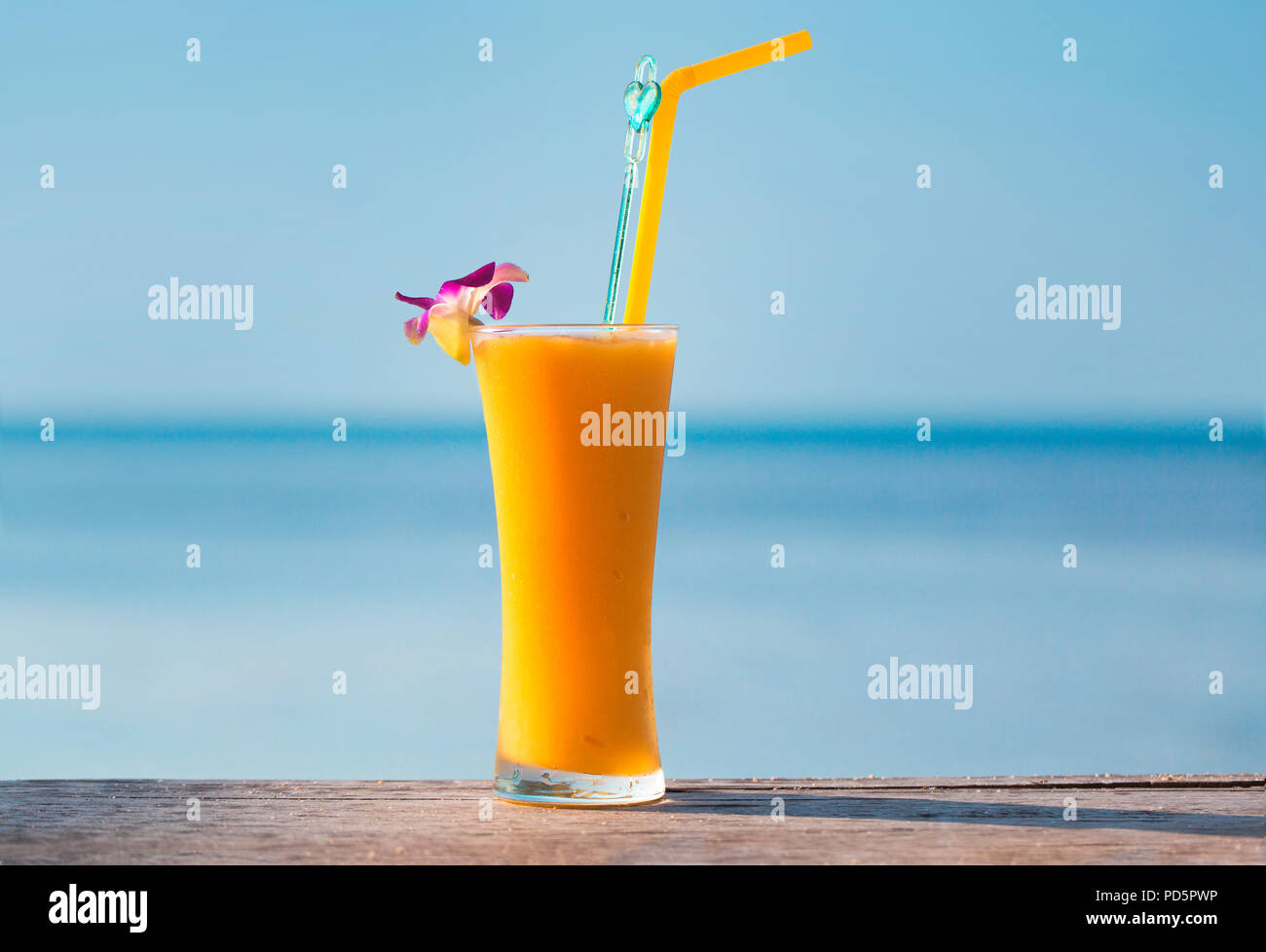 glass of fresh mango on the table on sea background Stock Photo - Alamy