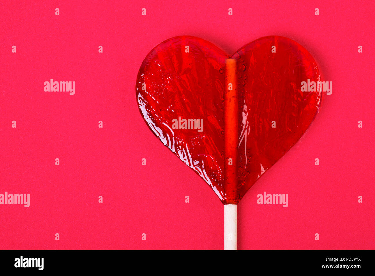 One candy heart shape on pink background Stock Photo - Alamy