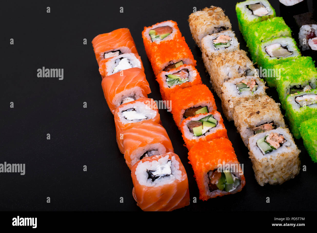 Japanese sushi rolls in the shape of a line on black background top ...