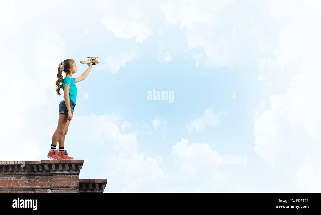 Concept of careless happy childhood with girl dreaming to become pilot ...