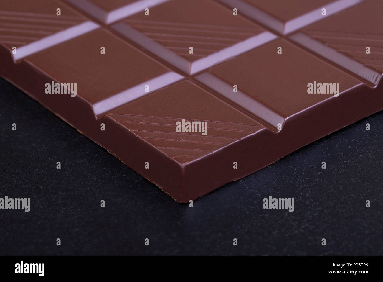 Milk chocolate bar on a black background closeup Stock Photo - Alamy