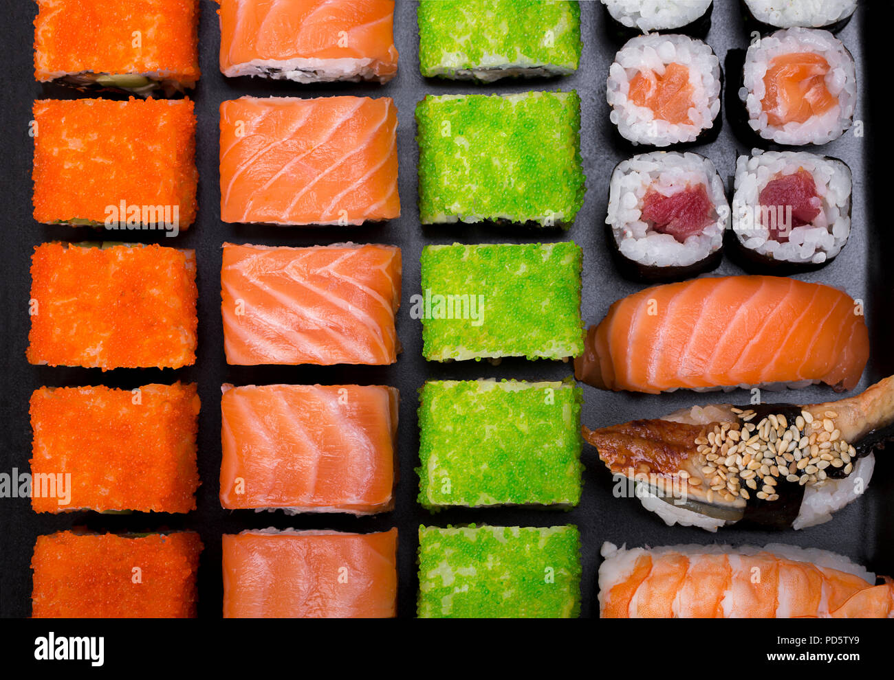 Japanese sushi rolls in the shape of a line on black background top ...