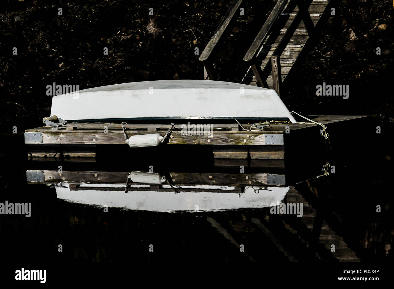 In low light the dark of the banking, and the white of the rowboat make ...