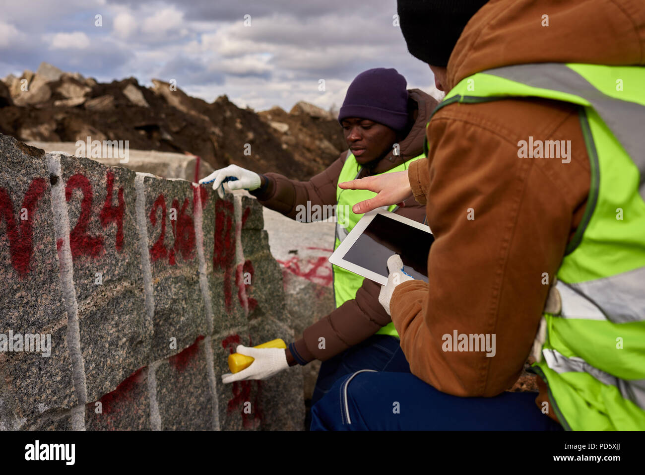 Side view portrait of two industrial workers wearing reflective jacket ...
