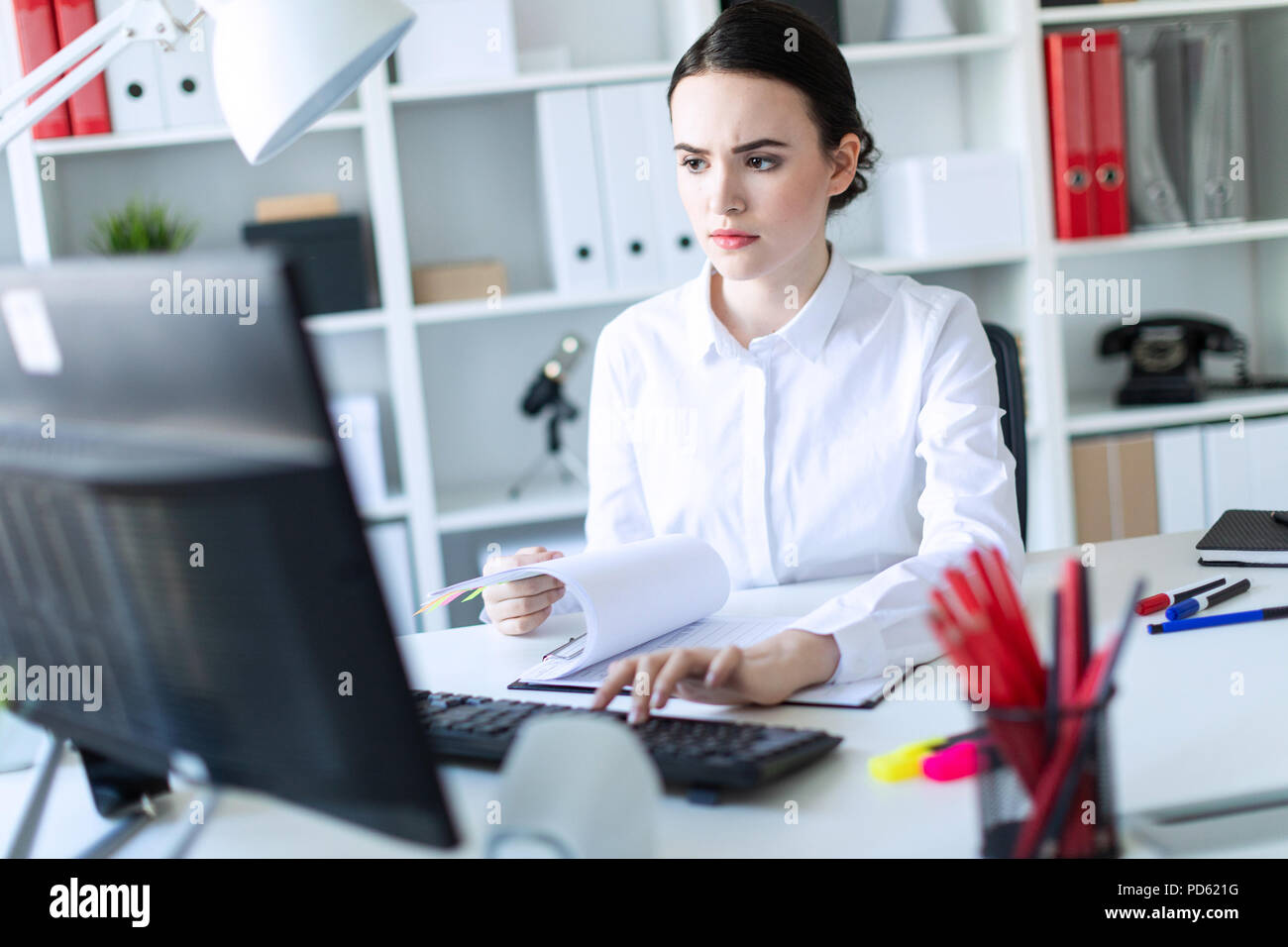 Young girl in the office working with documents at the computer Stock ...