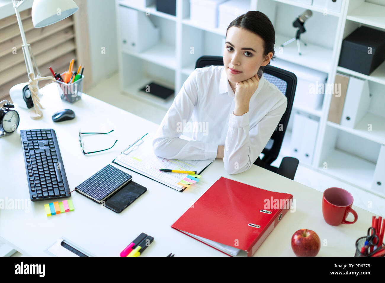 A young girl is sitting at the computer desk in the office Stock Photo ...