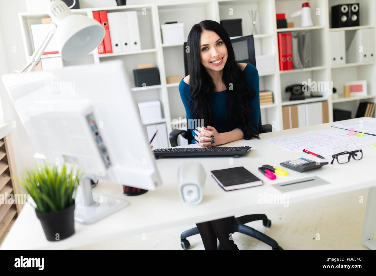 A young girl is sitting in the office at the table Stock Photo - Alamy