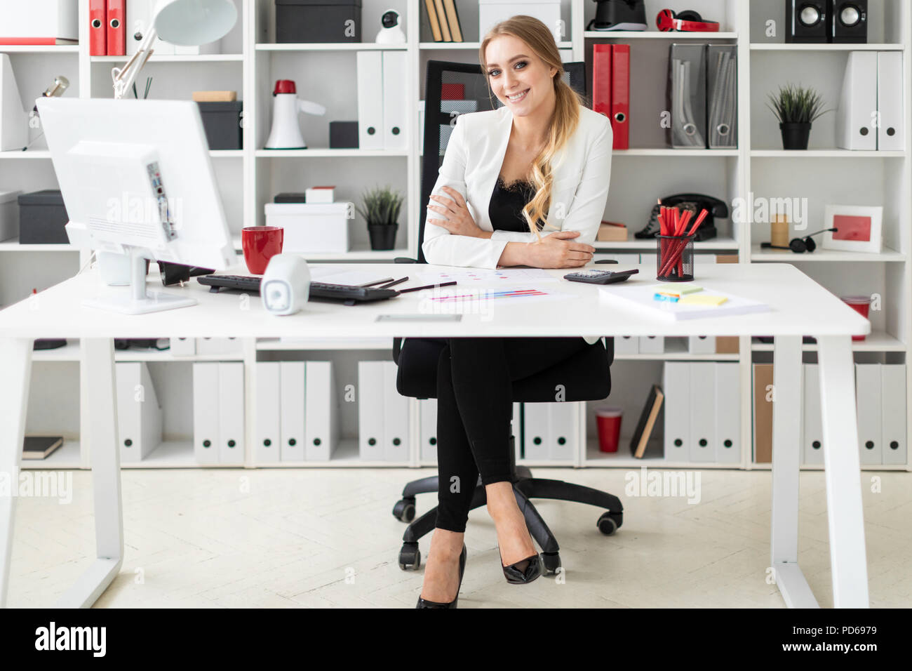 A young girl is sitting at the computer desk in the office Stock Photo ...