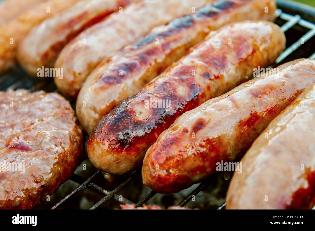 sausages and burgers cooking on the bbq Stock Photo - Alamy