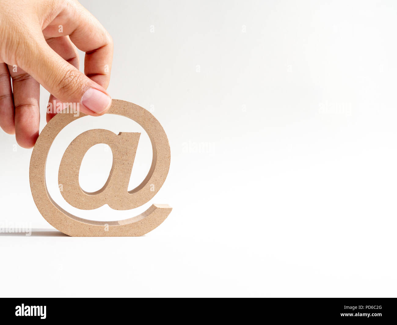 Hand putting wooden E-mail address symbol, arroba icon isolated on ...