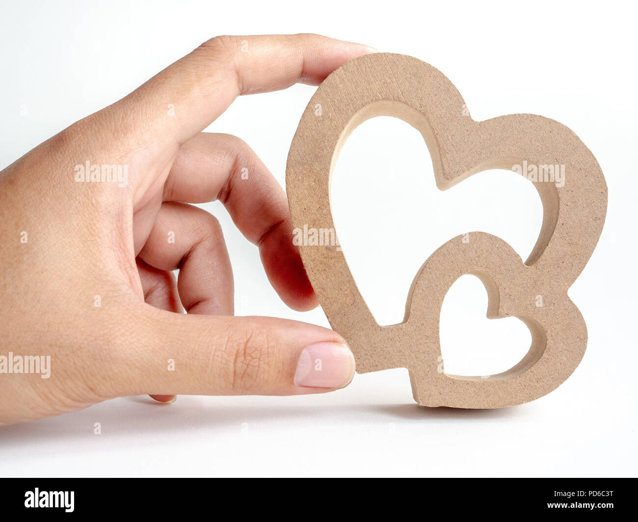 Hand touching wooden twin heart, Couple heart isolated on white ...