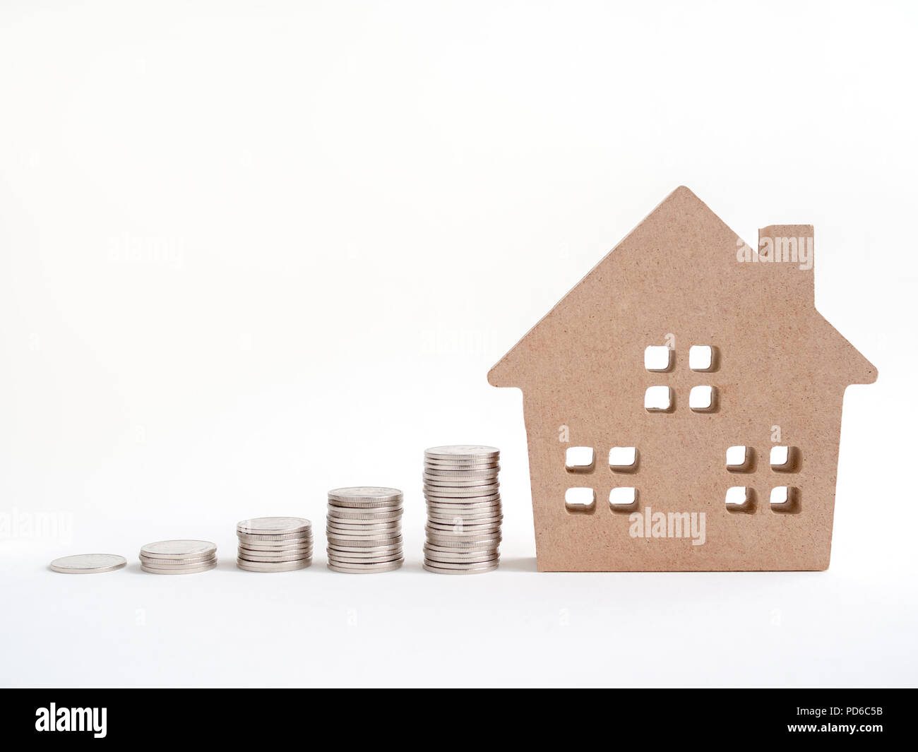 Money coins stack with wooden house isolated on white background with ...