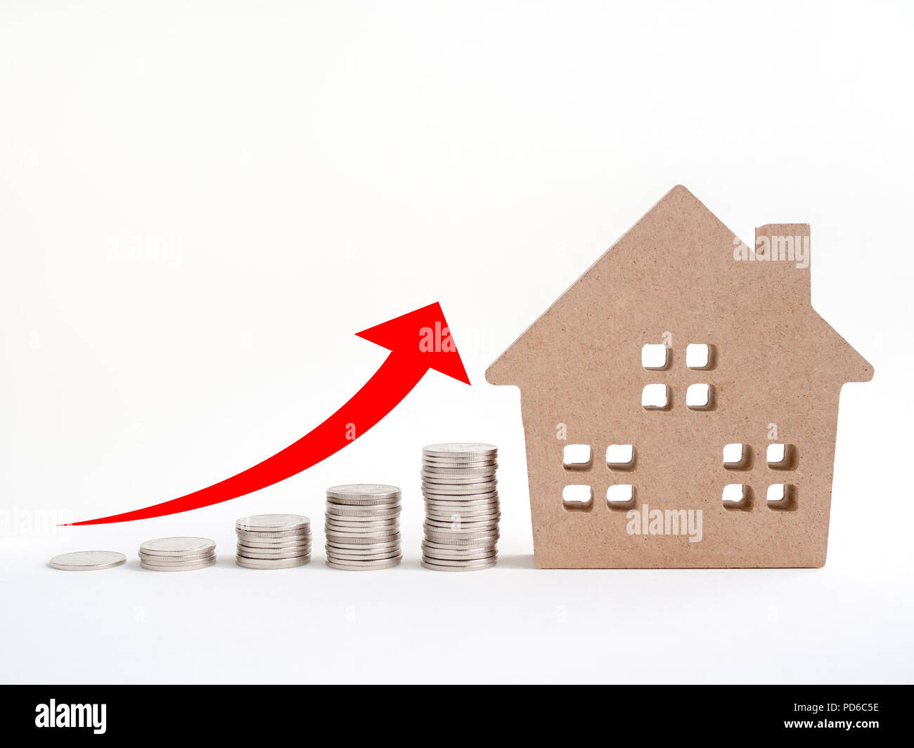 Money coins stack with wooden house and red arrow risin graph isolated ...