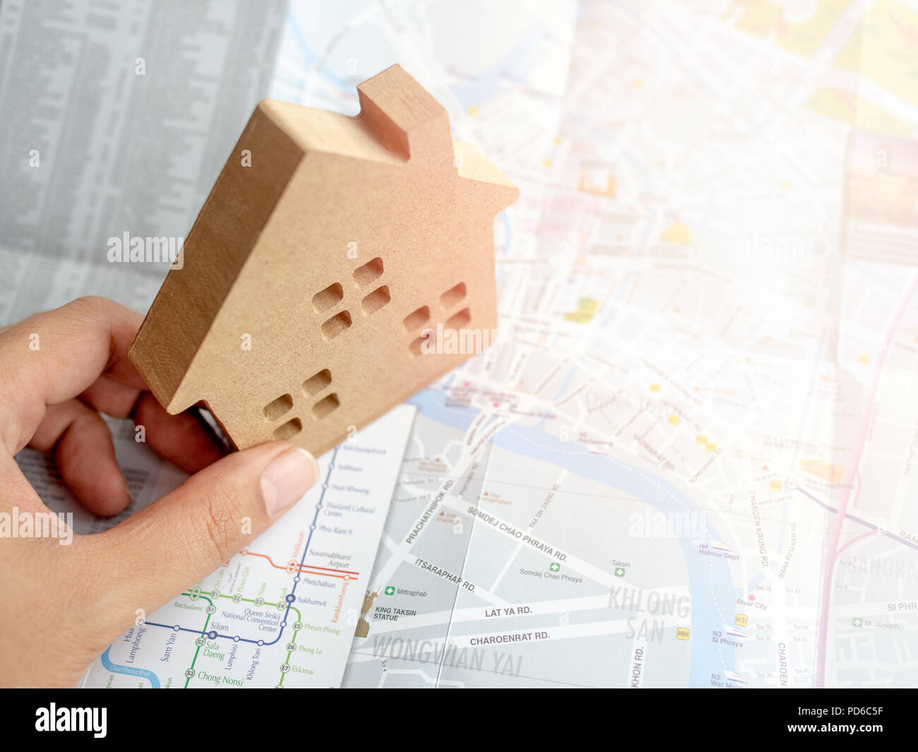 Wooden house in hand on map background top view with copy space ...