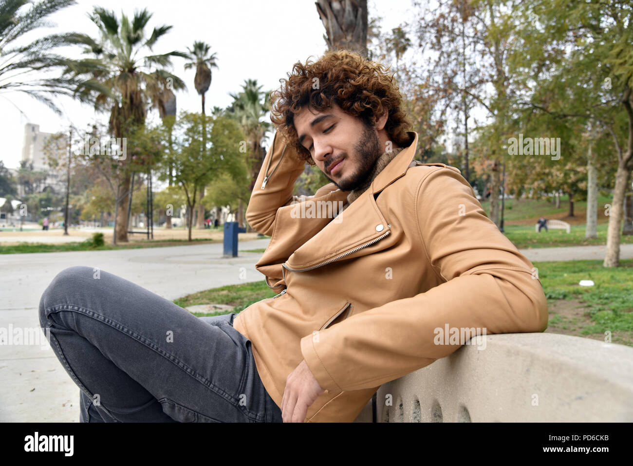 A handsome multi-ethnic young man napping in the park Stock Photo - Alamy