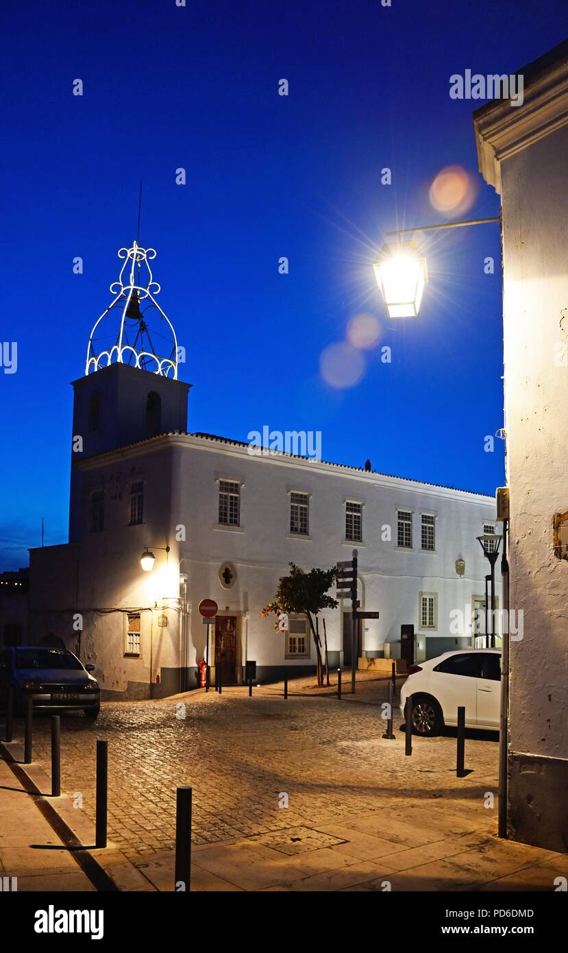 View along an old town street towards the clock tower (Torre de Relogio ...
