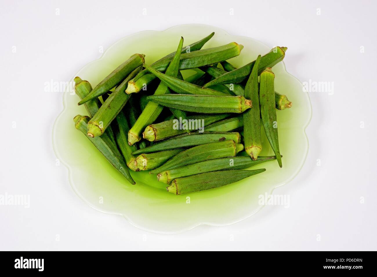Whole raw okra against a white background Stock Photo - Alamy