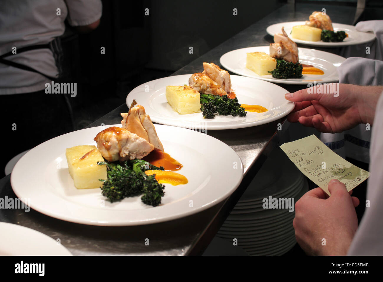 preparing plated food at the kitchen pass Stock Photo - Alamy