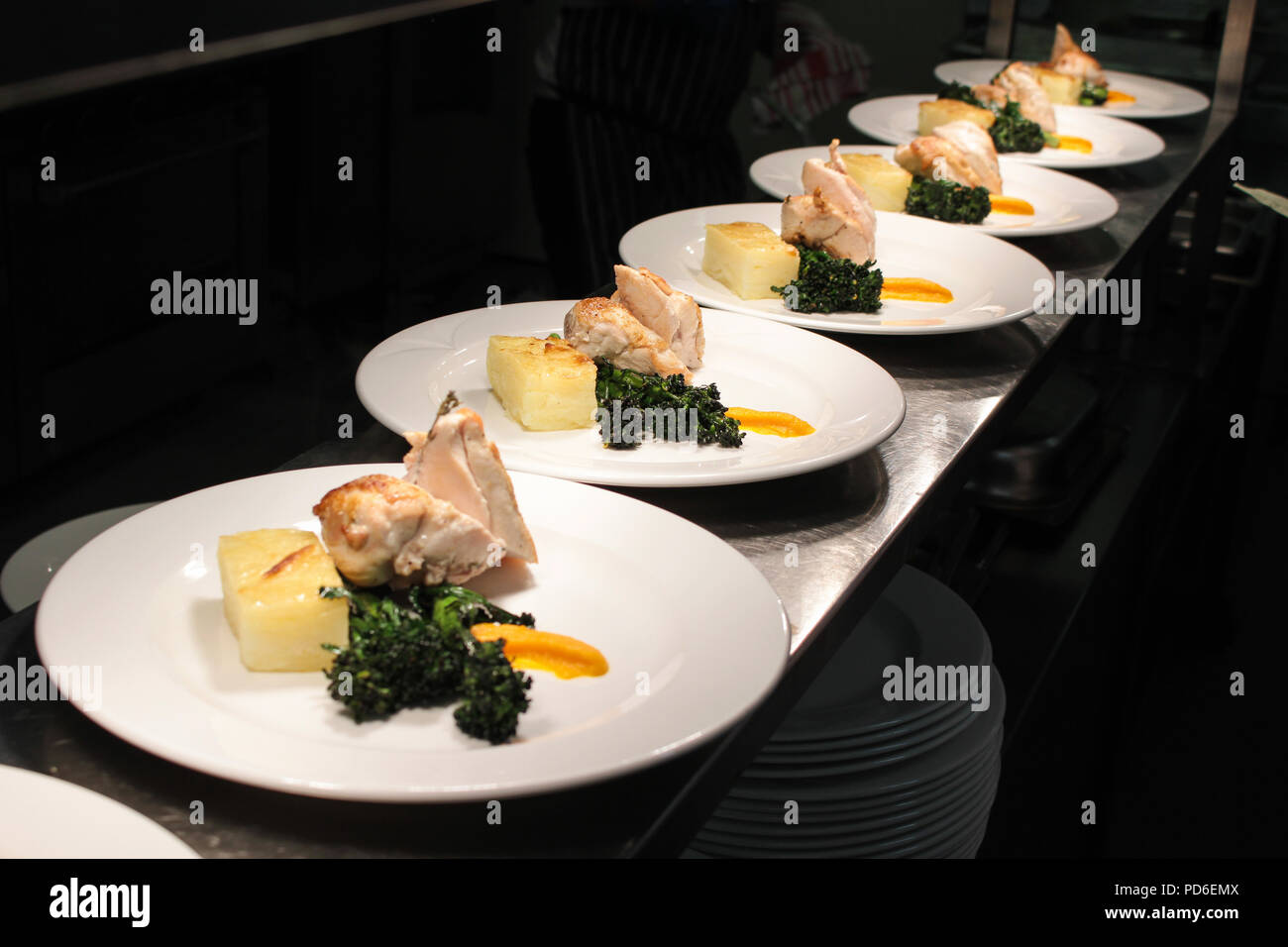 preparing plated food at the kitchen pass Stock Photo - Alamy