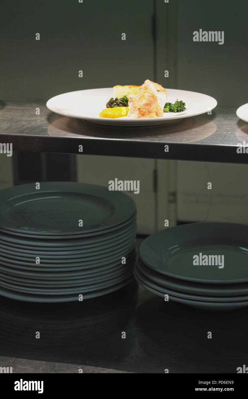 preparing plated food at the kitchen pass Stock Photo - Alamy