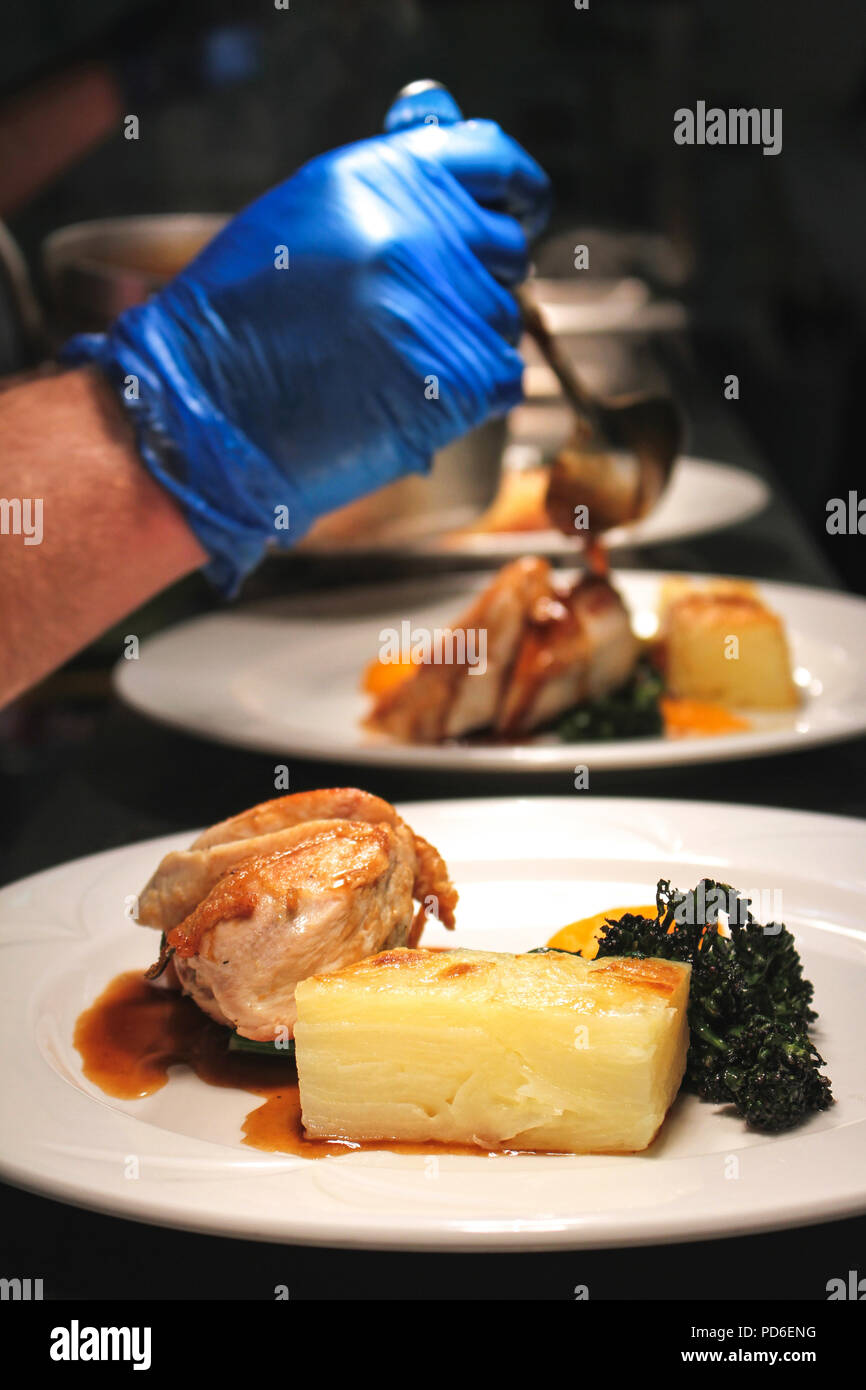 preparing plated food at the kitchen pass Stock Photo - Alamy