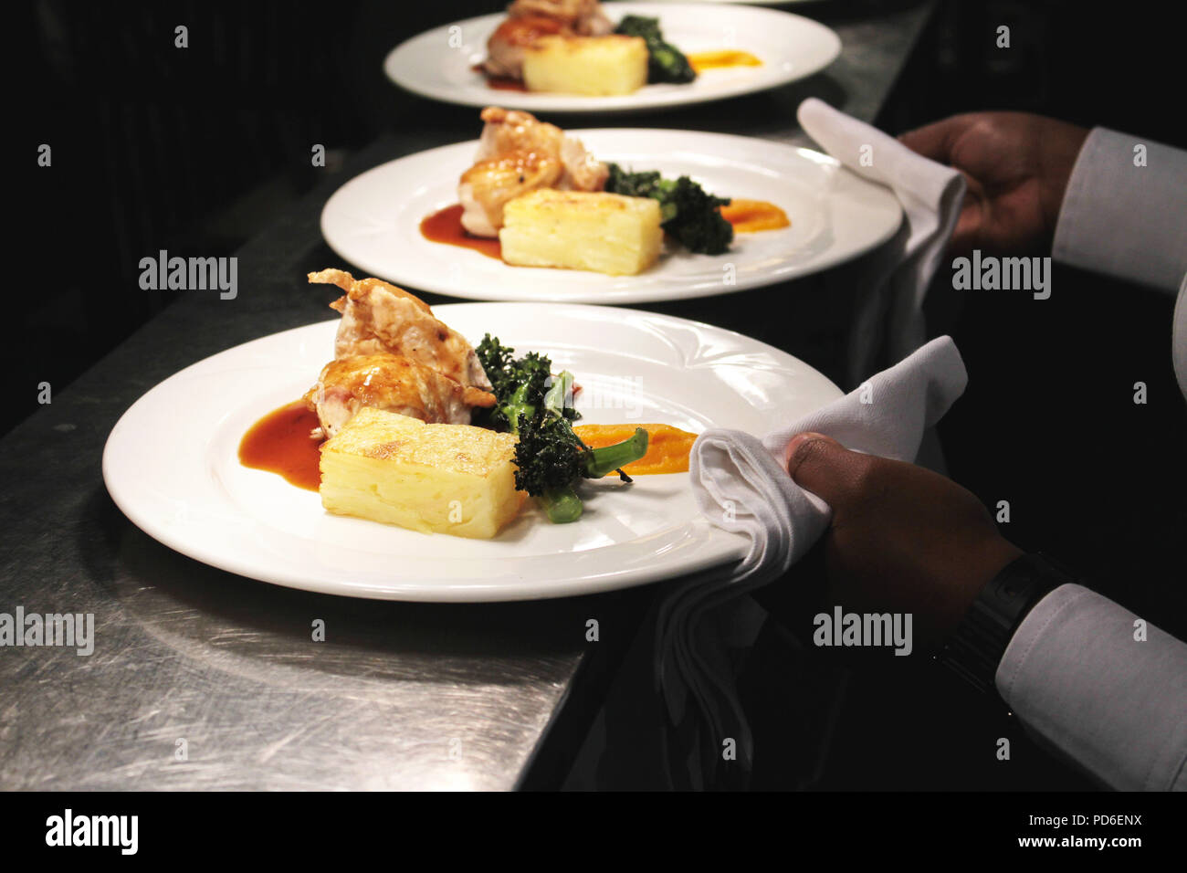 preparing plated food at the kitchen pass Stock Photo - Alamy