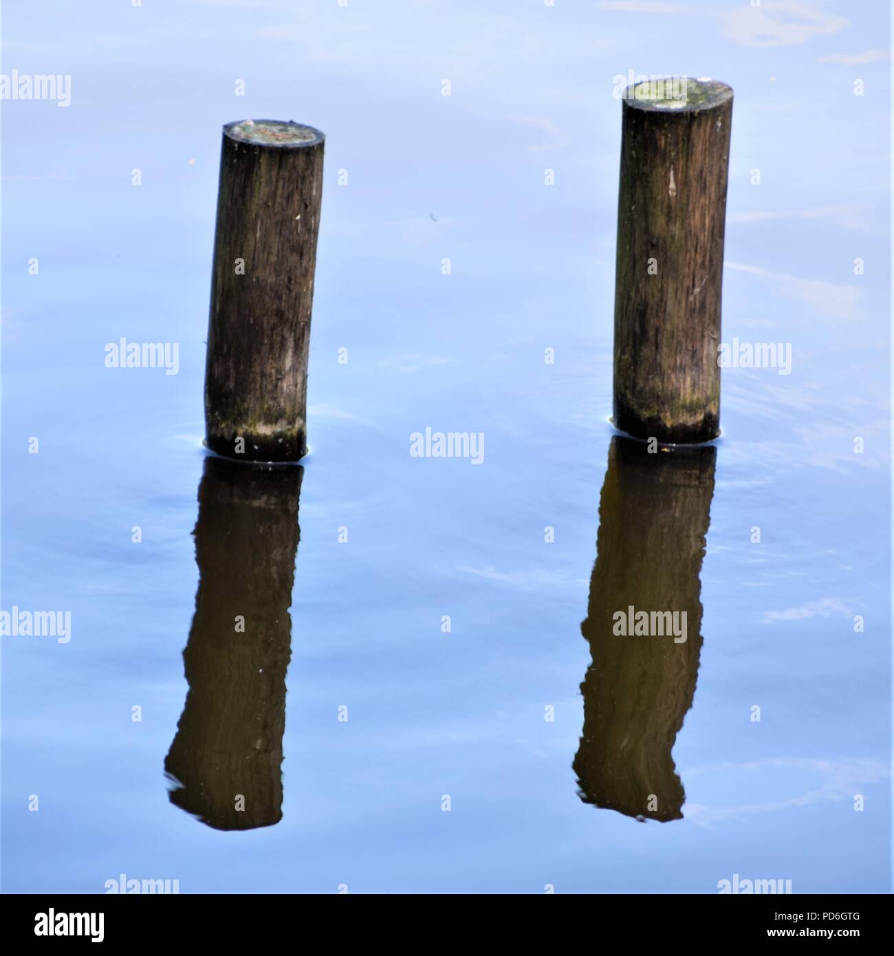 Reflection of two wood sticks in the water Stock Photo - Alamy