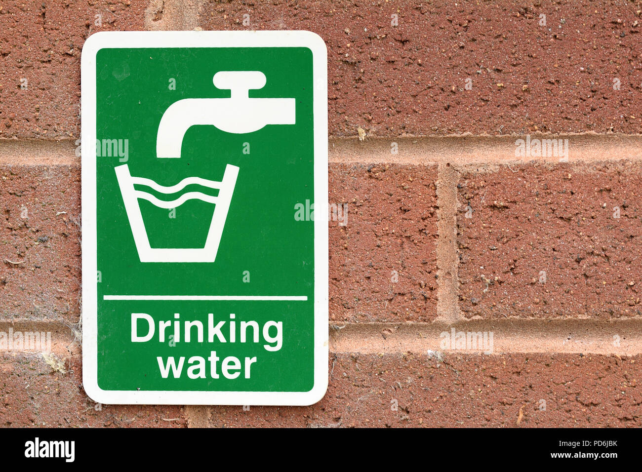 Drinking water sign with white text and tap faucet symbol and glass ...
