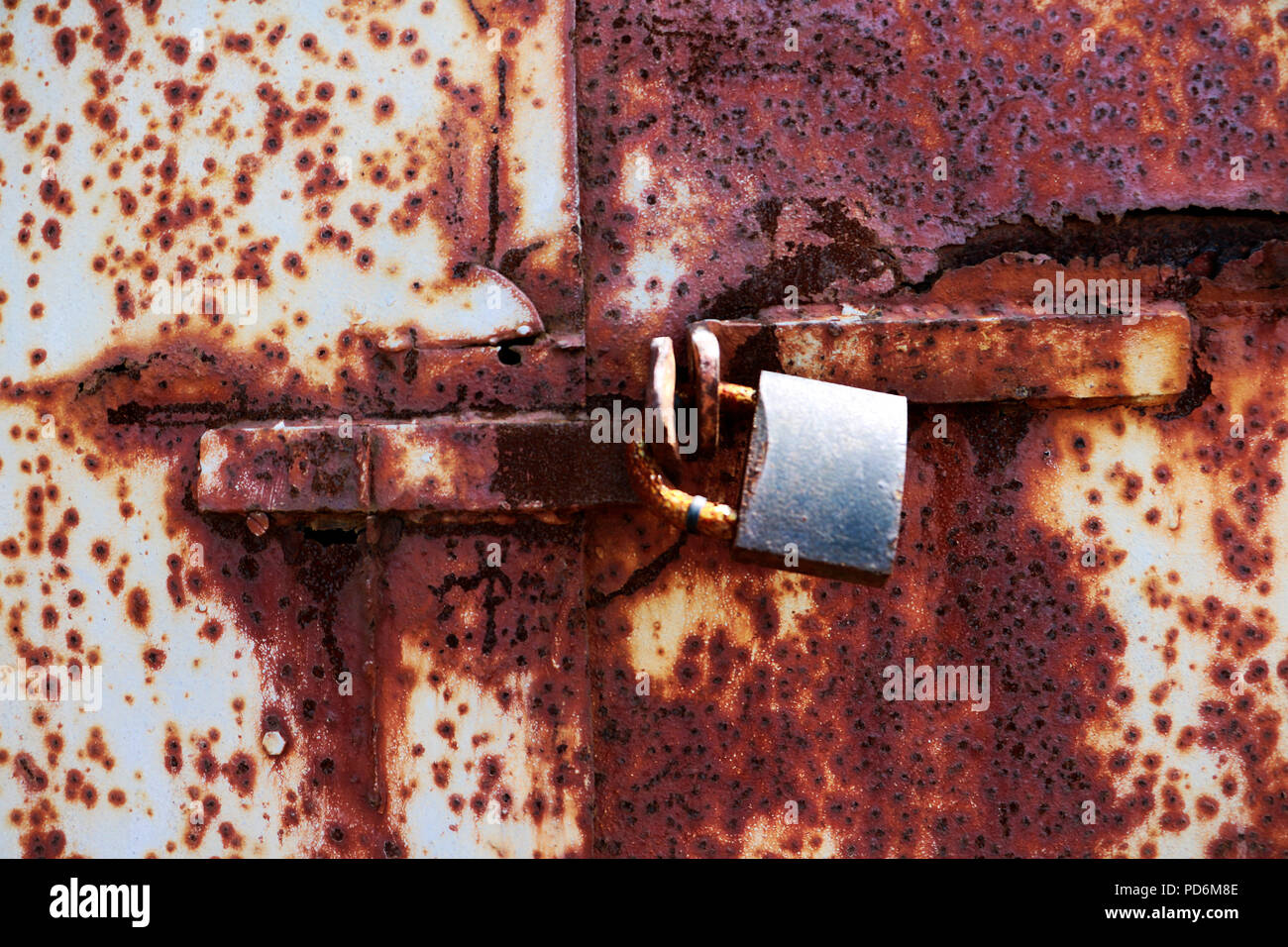 old rusted lock on a white and brown rusty gate. Rusty old lock on red ...