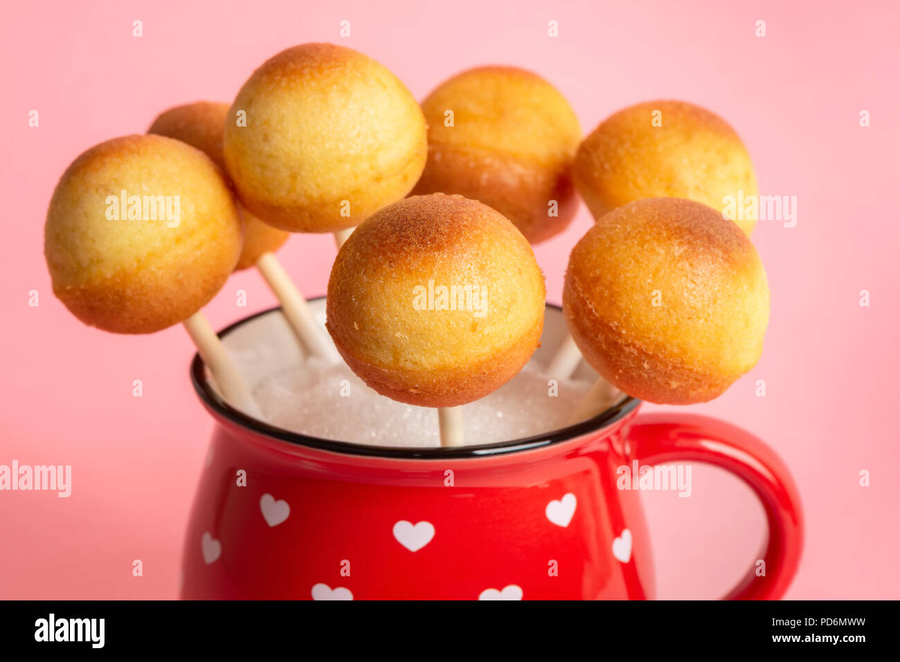baked pop cakes in cup over pink background, close up Stock Photo - Alamy