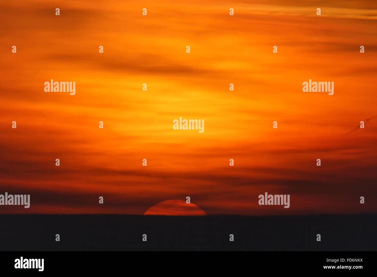 The sun disappearing over the horizon Stock Photo - Alamy