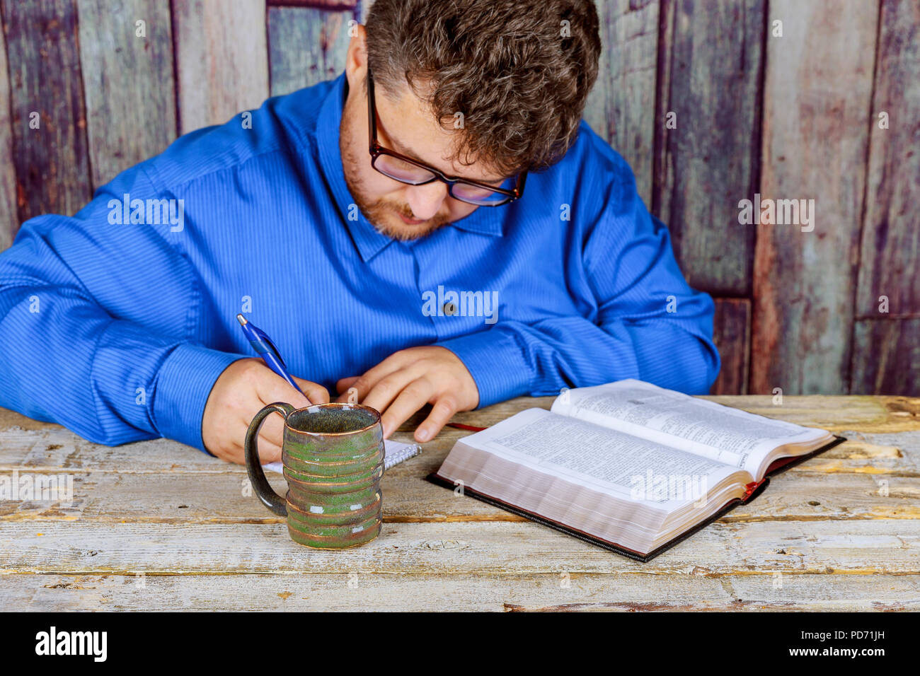 Man reading Bible in the church behind a wooden table Stock Photo - Alamy