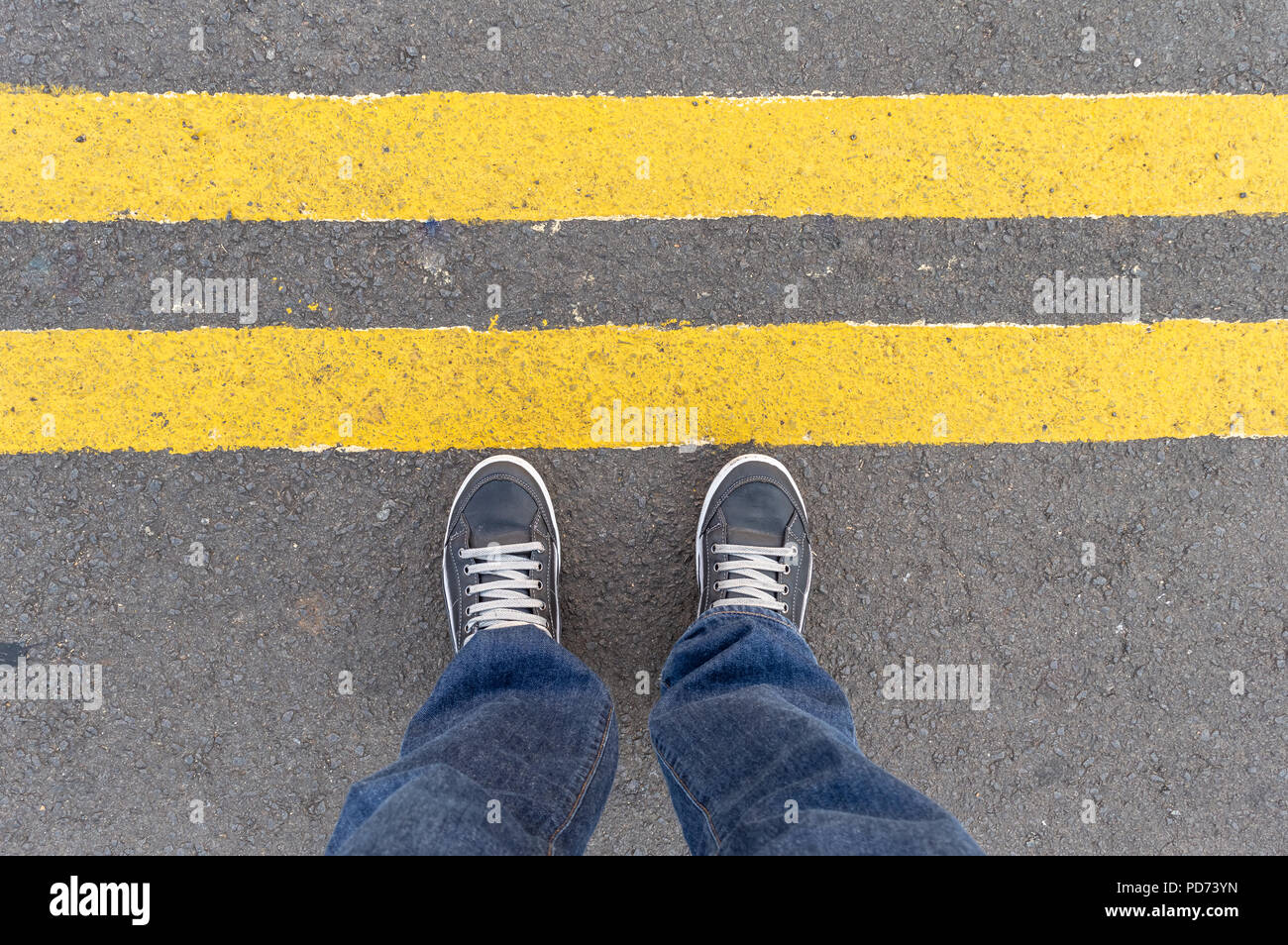 Personal perspective of person's feet looking at the street's yellow ...