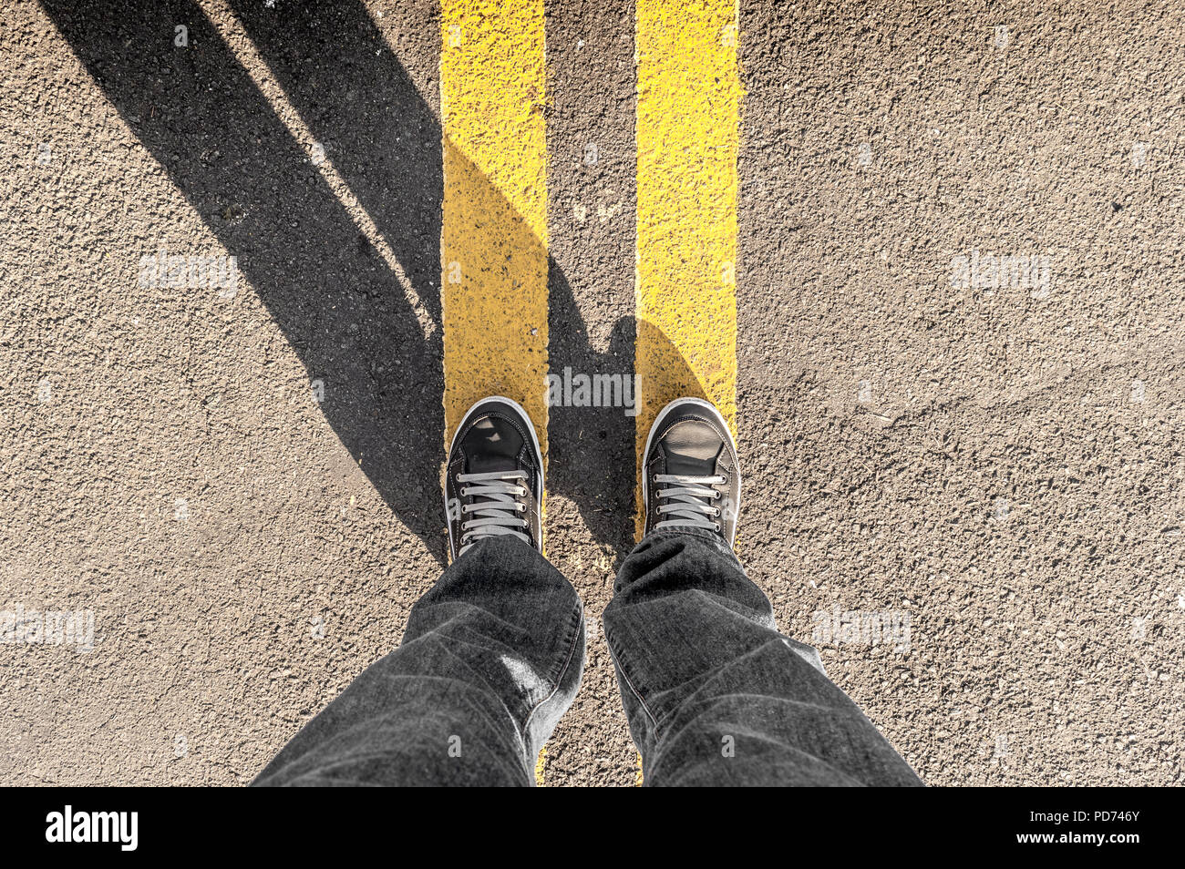 Personal perspective of person's legs and street's yellow lines Stock ...